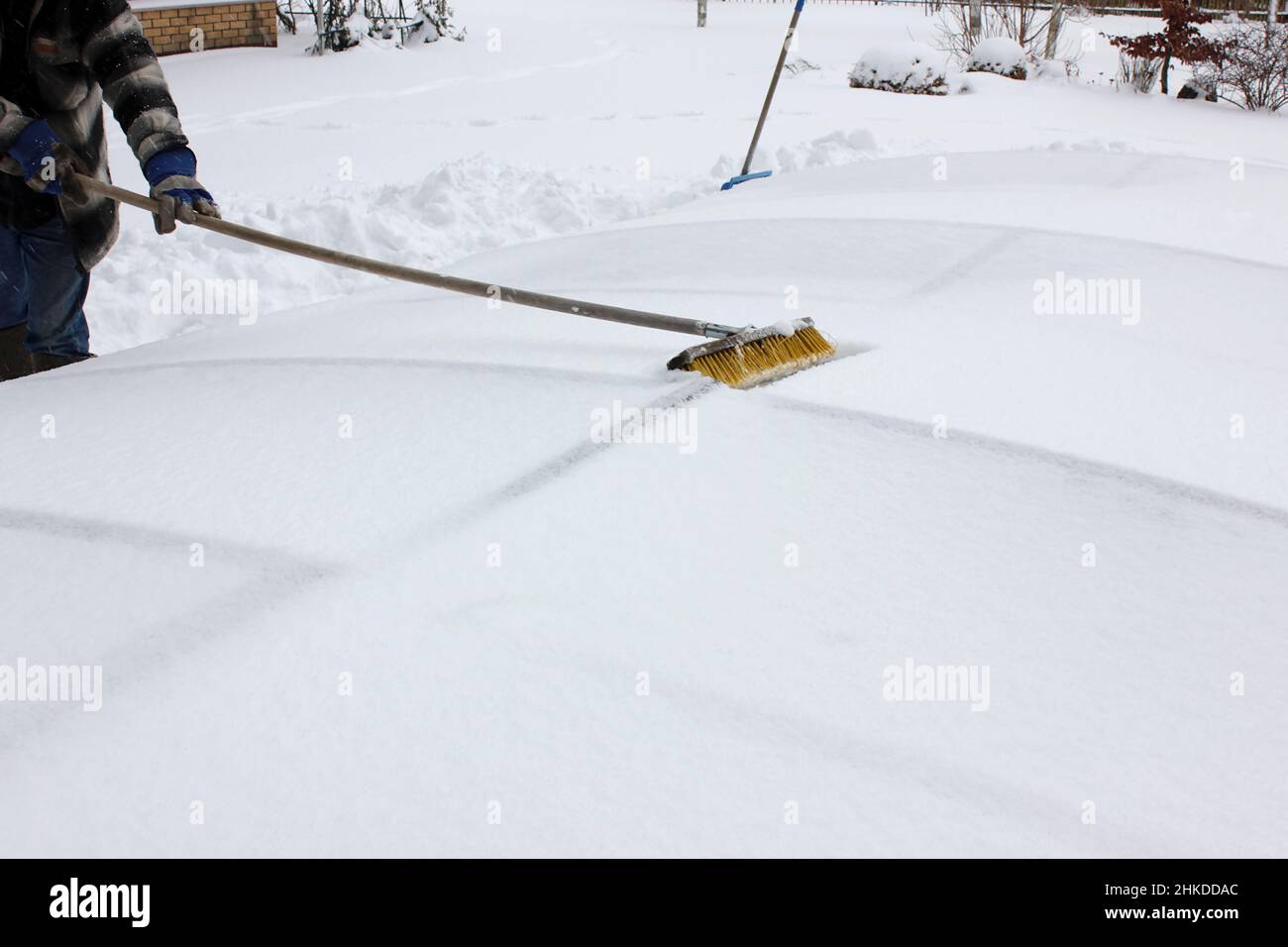 A man clears snow from an outdoor pool in a private yard. Water pool ...