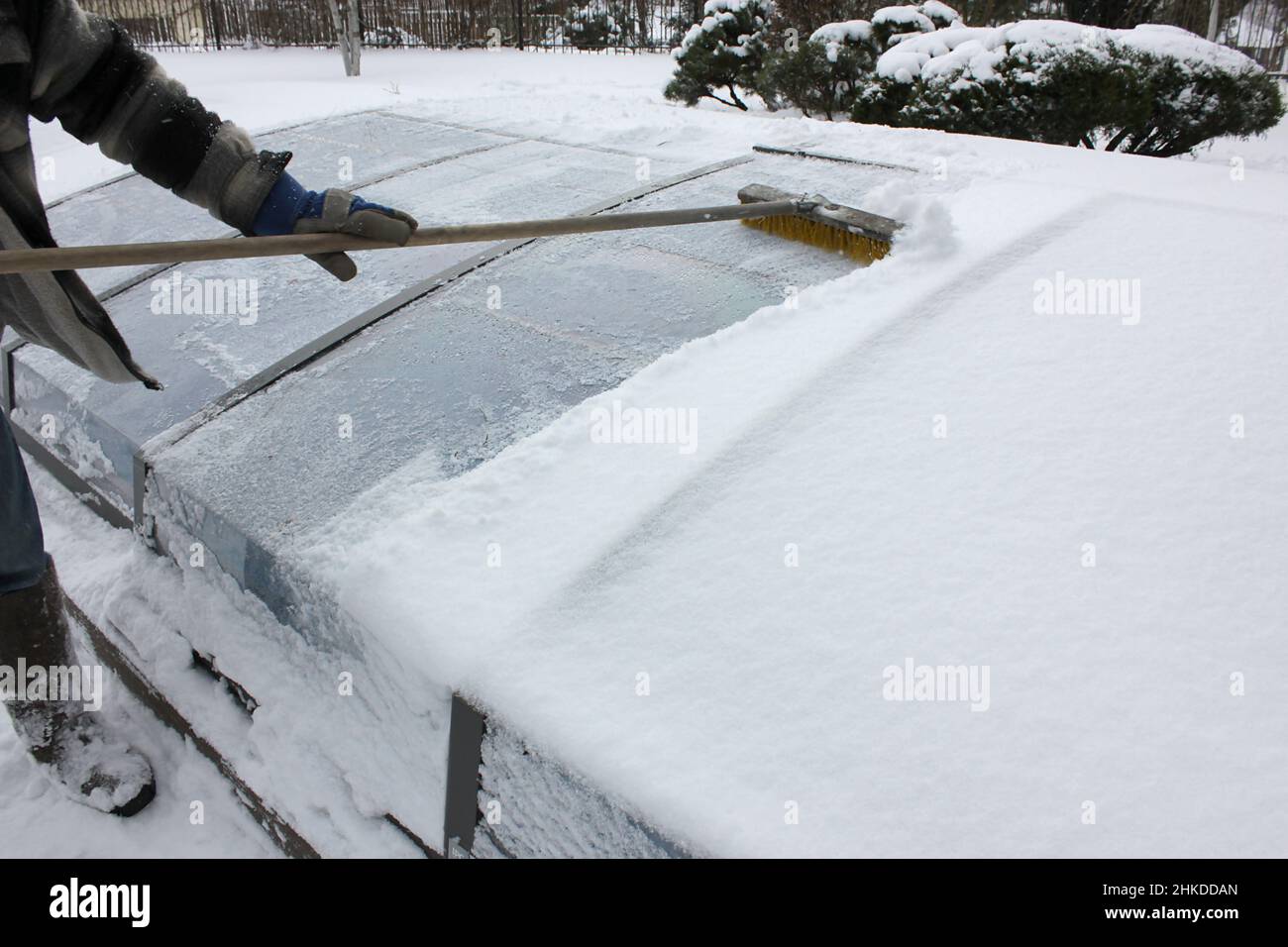 A man clears snow from an outdoor pool in a private yard. Water pool ...
