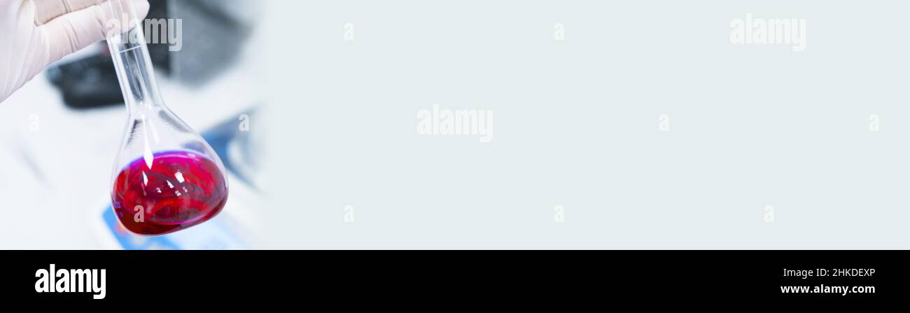 Banner of scientist holding a flask with red reagent with analytical ...