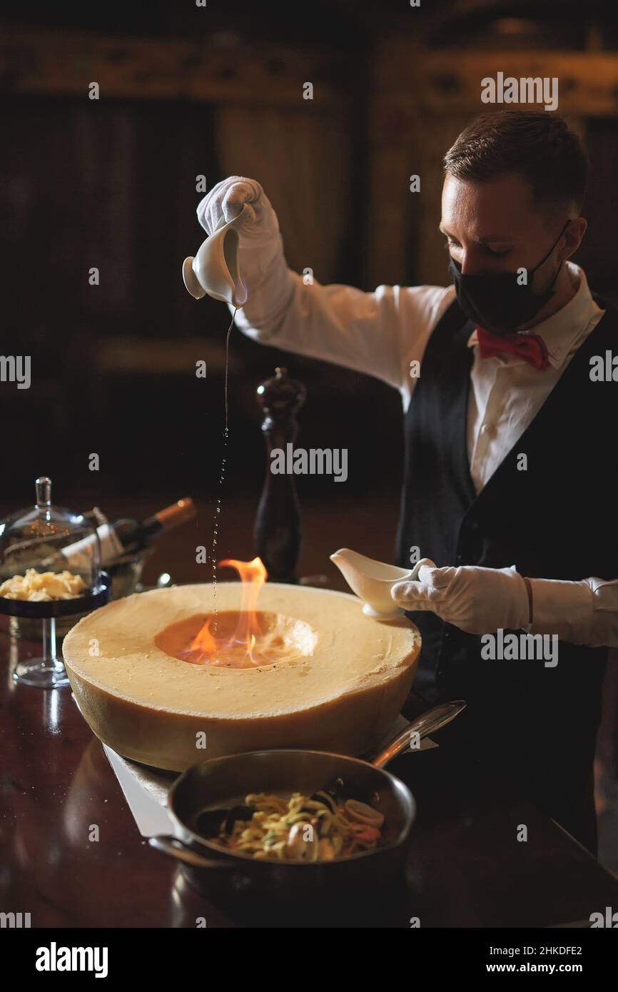 The waiter flambit Parmesan cheese in the restaurant for guests Stock ...