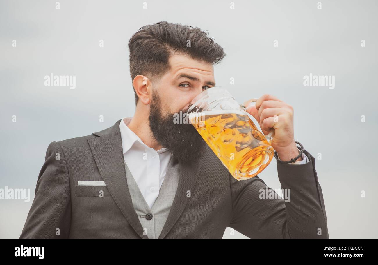 Man in classic suit drinking beer. Bearded guy in classic outfit looks ...