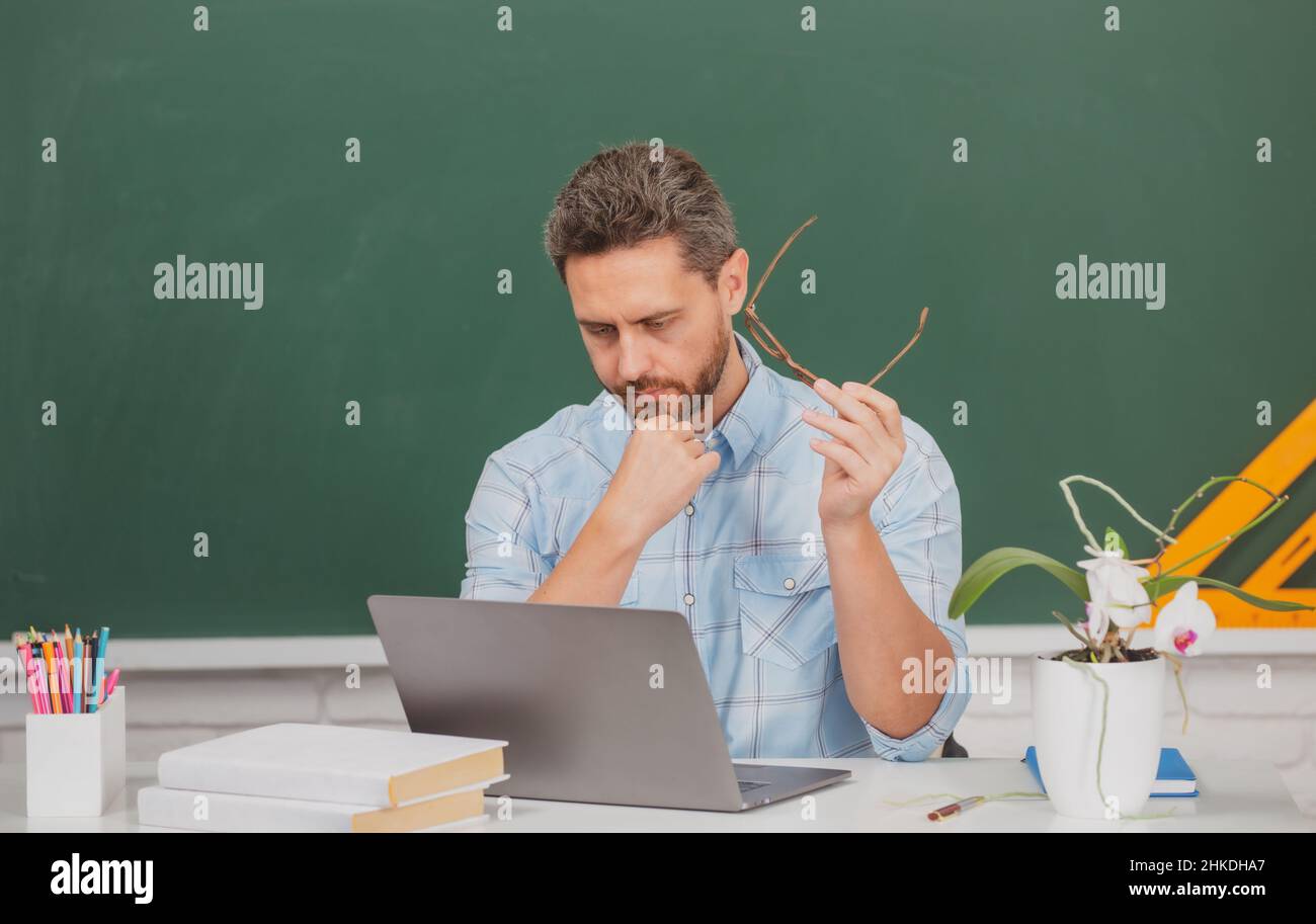 Teacher in classroom at university or college. Male student on board ...