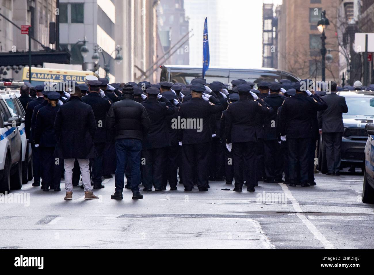 NYPD officers salute during the processional of fallen NYPD officer ...
