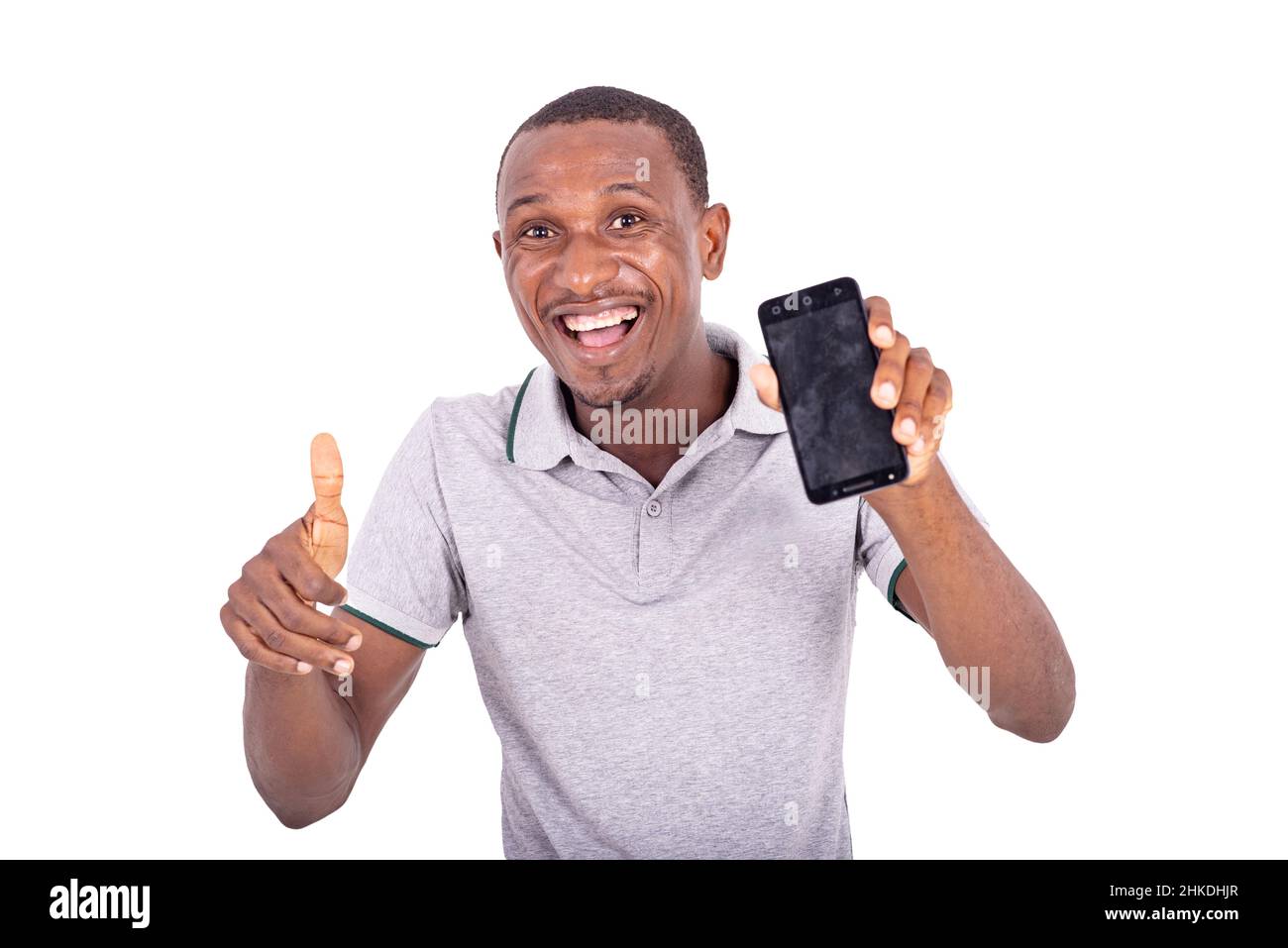 handsome happy young man holding mobile phone and showing his thumb ...