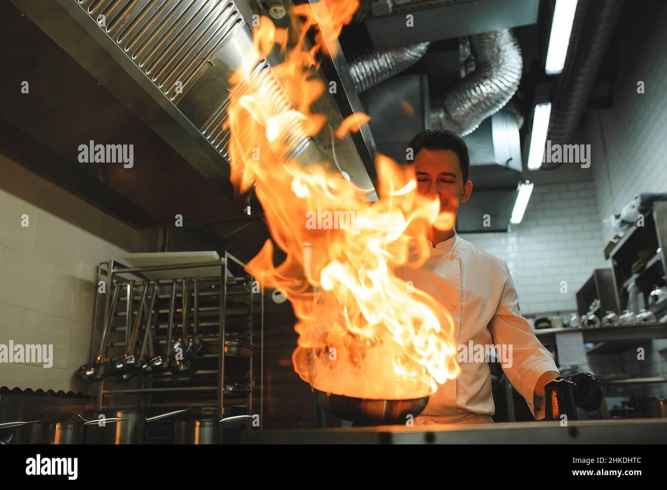 Close-up of the chef's hands cooking food on fire. The chef burns food ...