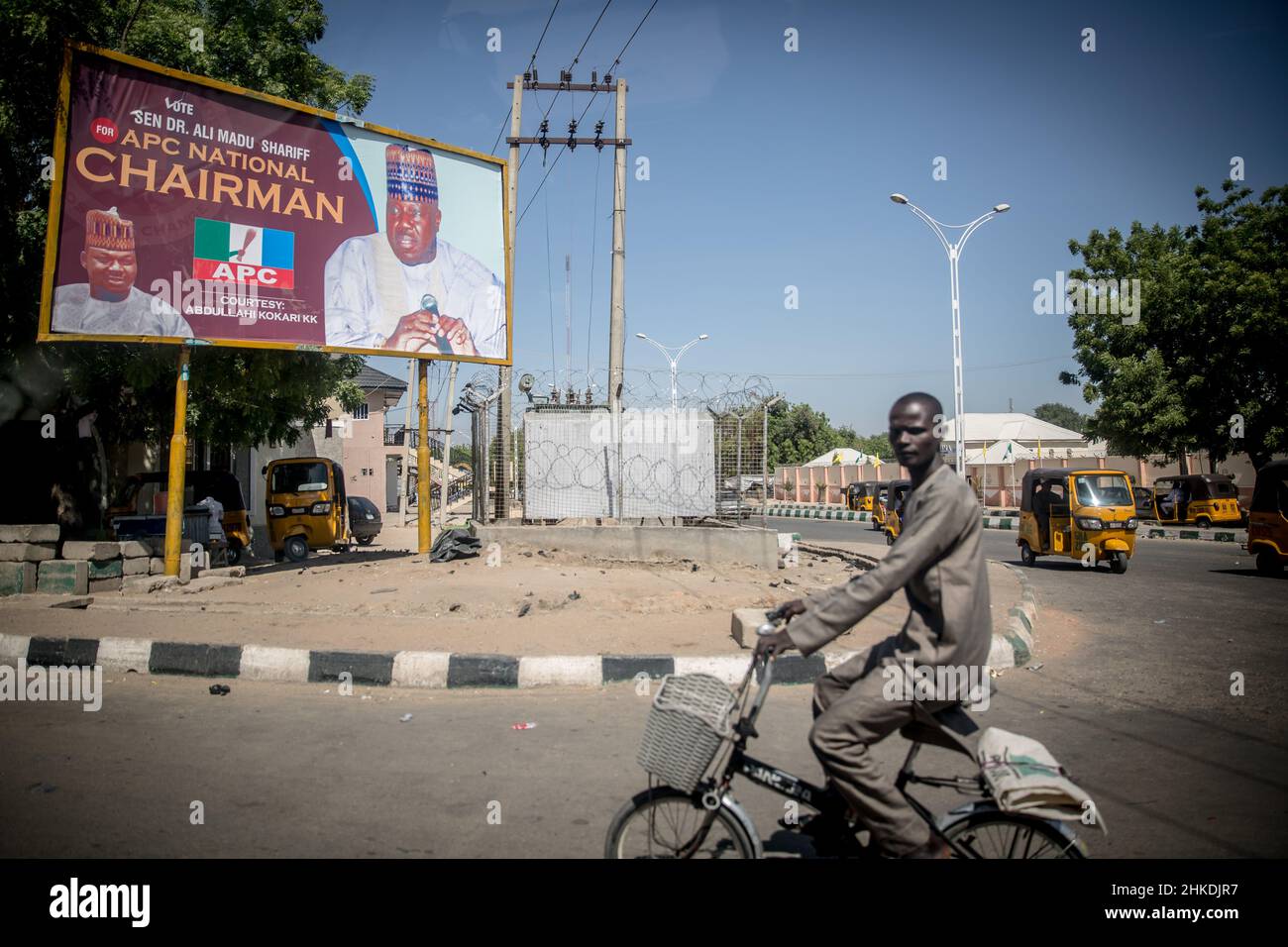A man cycles past an election billboard in Maiduguri, the capital of ...