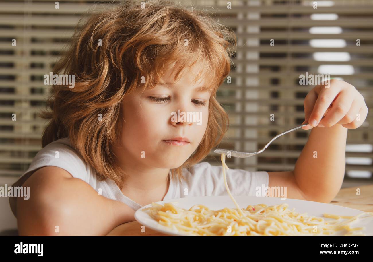 Portrait of little boy eating pasta, spaghetti. Concept of kids face ...