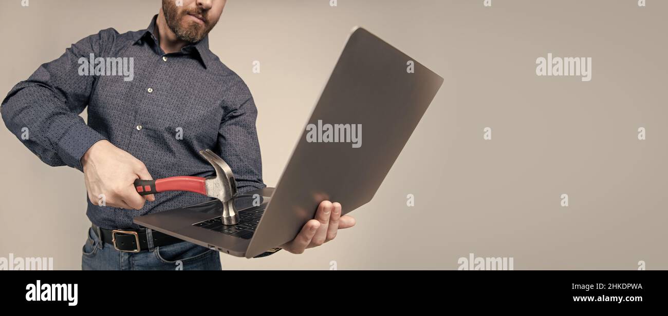 Bearded man cropped view beat with hammer breaking into computer grey ...