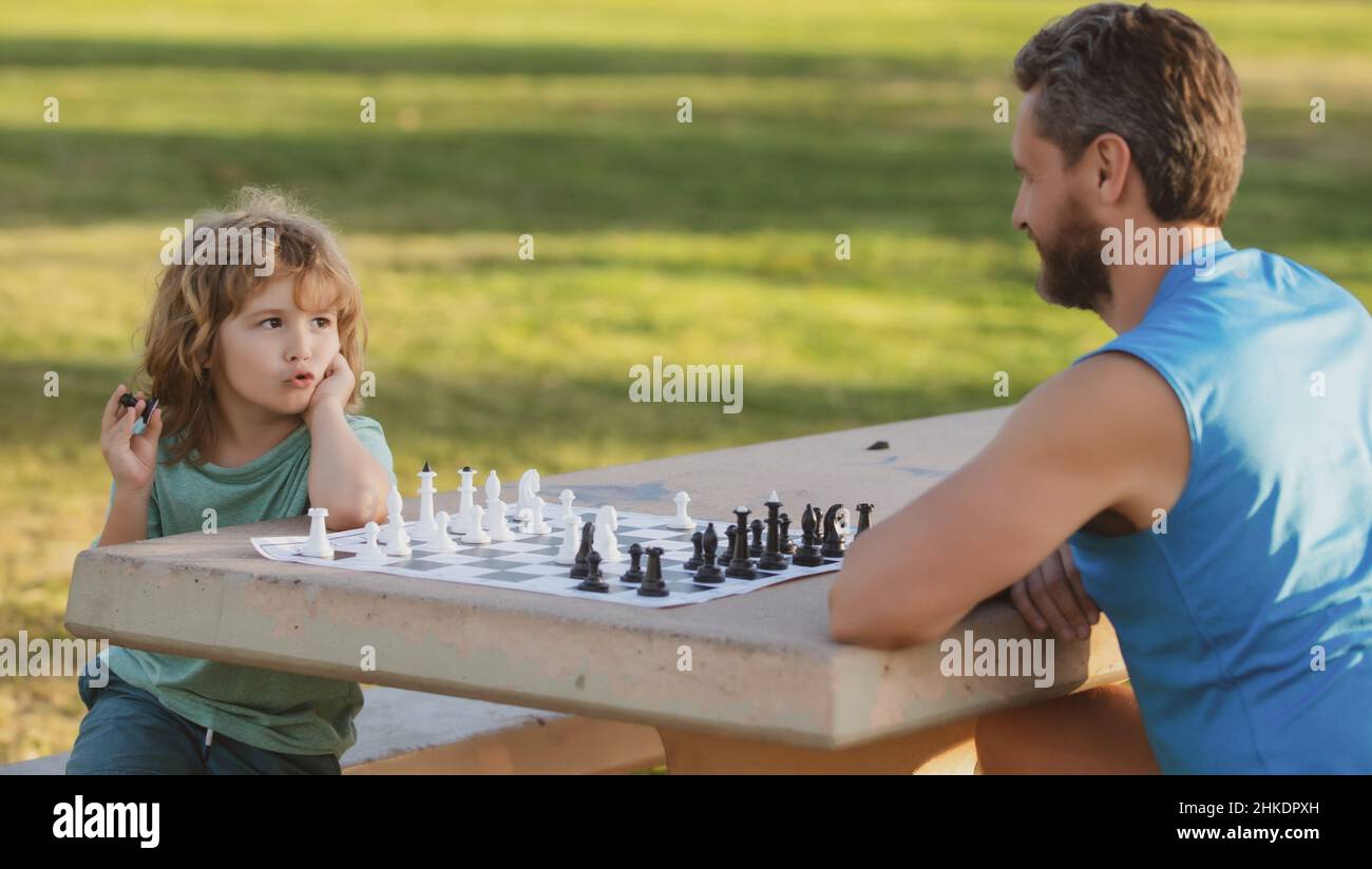 Father and son playing chess spending time together in park. Games and ...