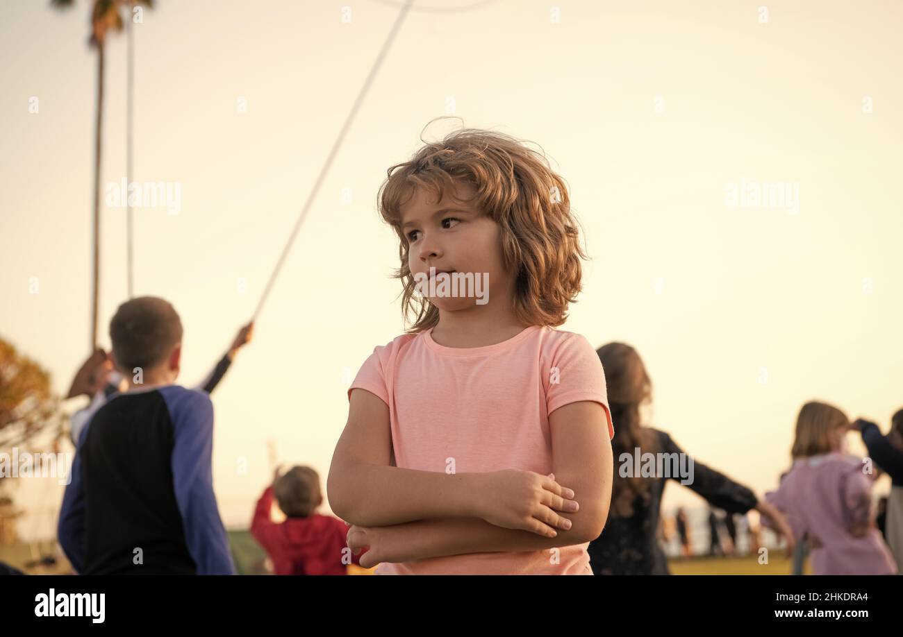 He is a very serious kid. Caucasian kid summer outdoors. Boy stand ...