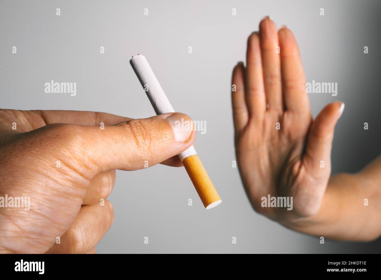 Woman showing stop sign with hand and refusing to take cigarette. No ...