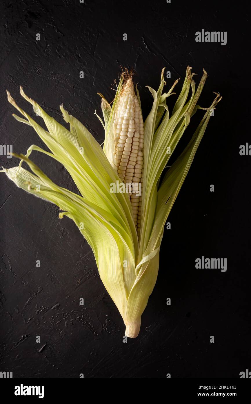 Top View Image of raw white corn on the cob on black rustic surface ...