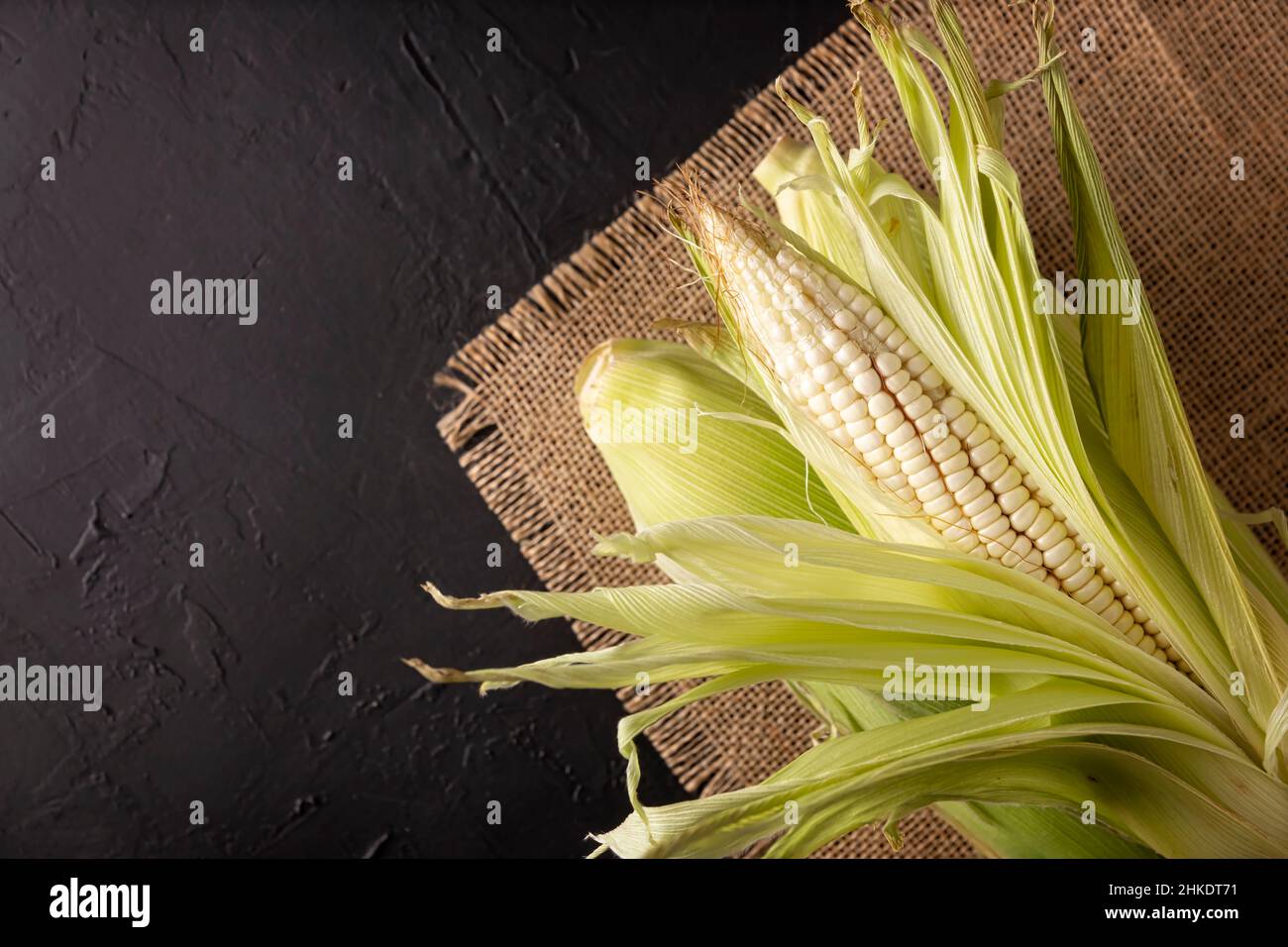 Top View Image of raw white corn on the cob on black rustic surface ...