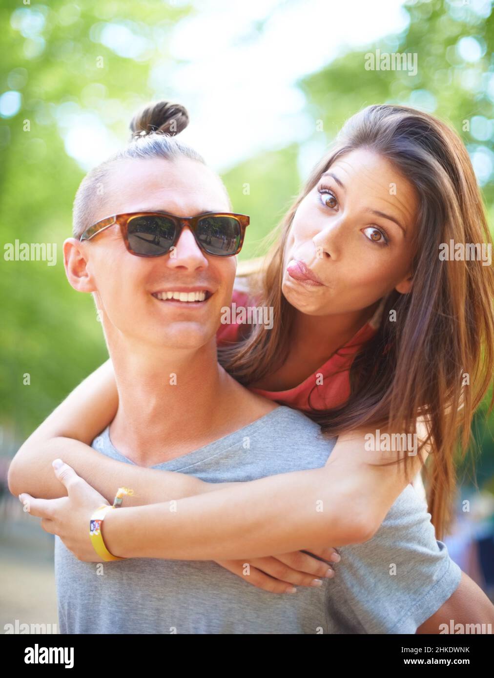 Care-free couple. A trendy young man giving his female friend a ...