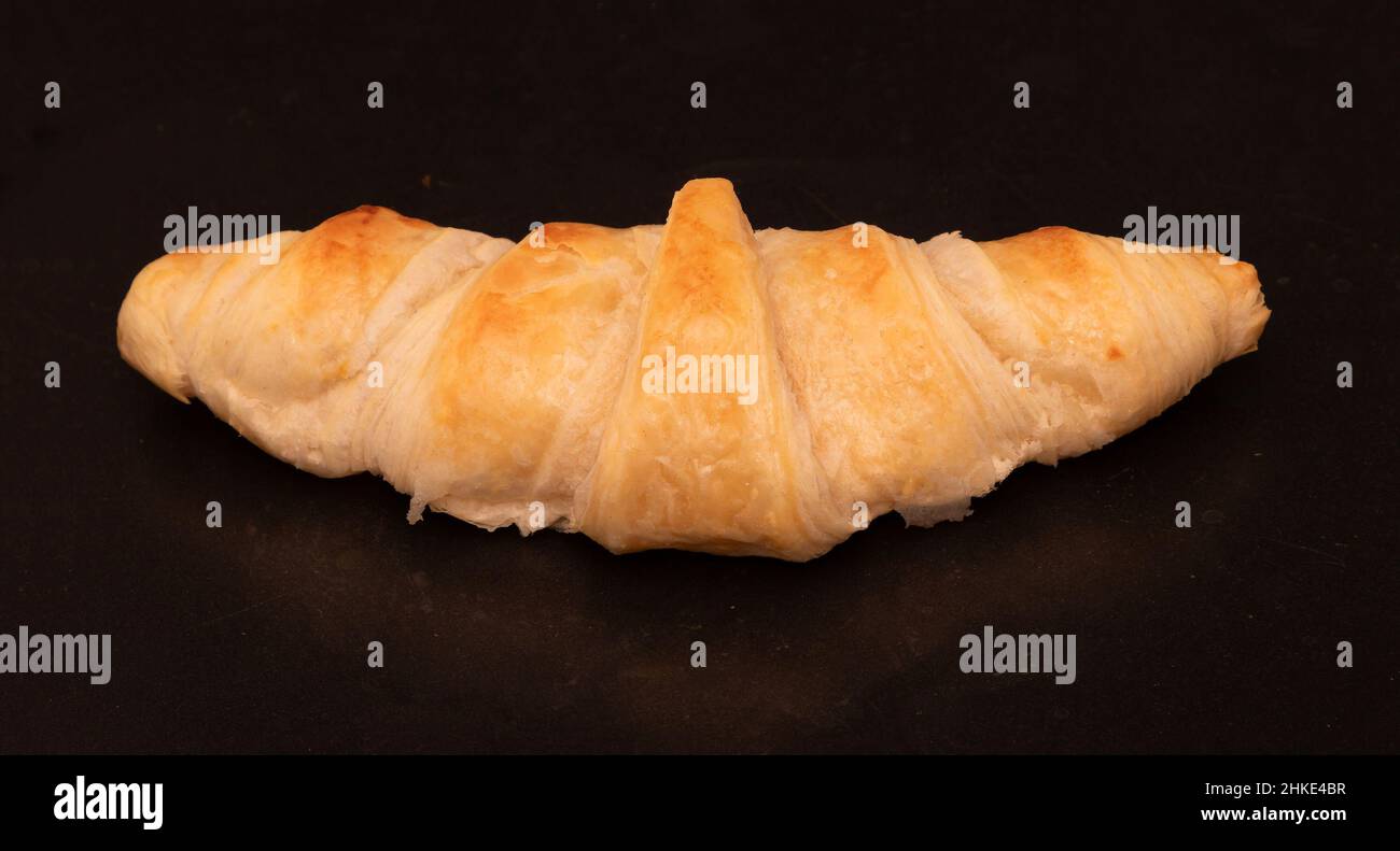 Crispy baked crunchy butter croissant pastry on black background Stock ...