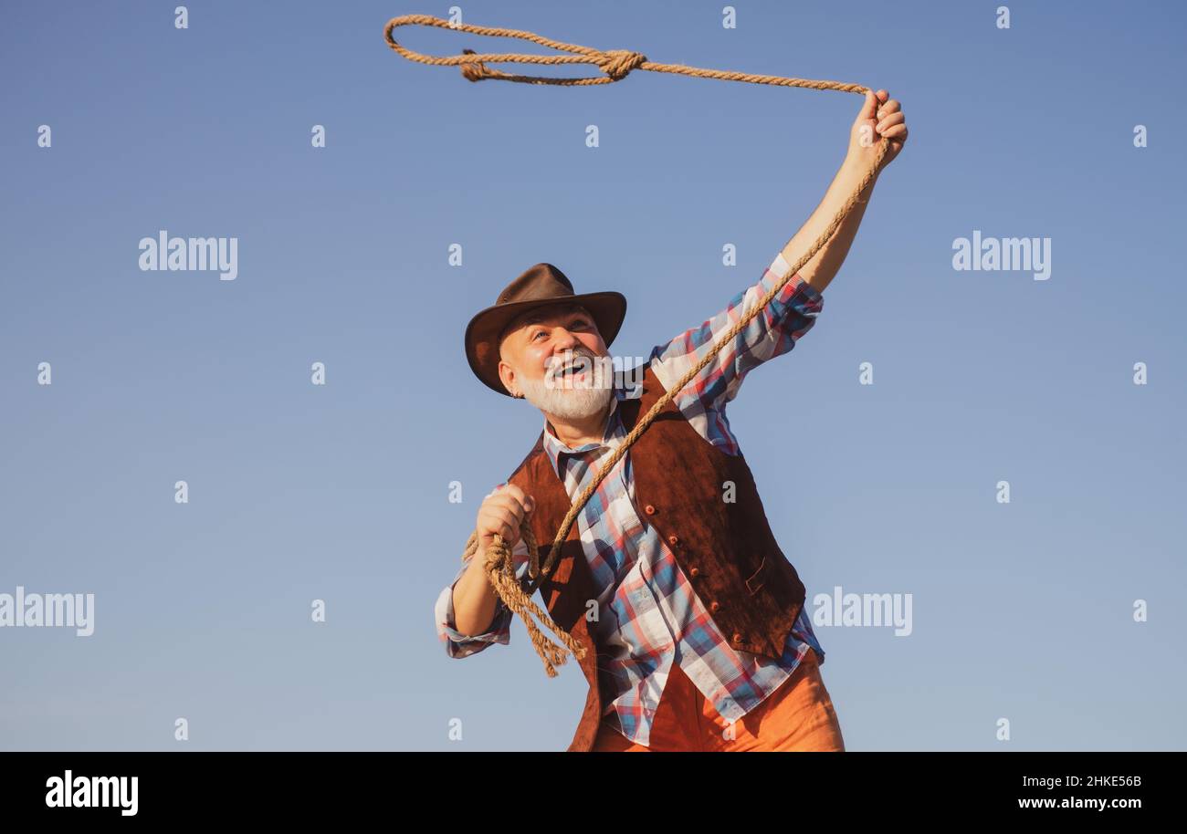 Old wild west cowboy at rodeo. Western pensioner with lasso rope ...