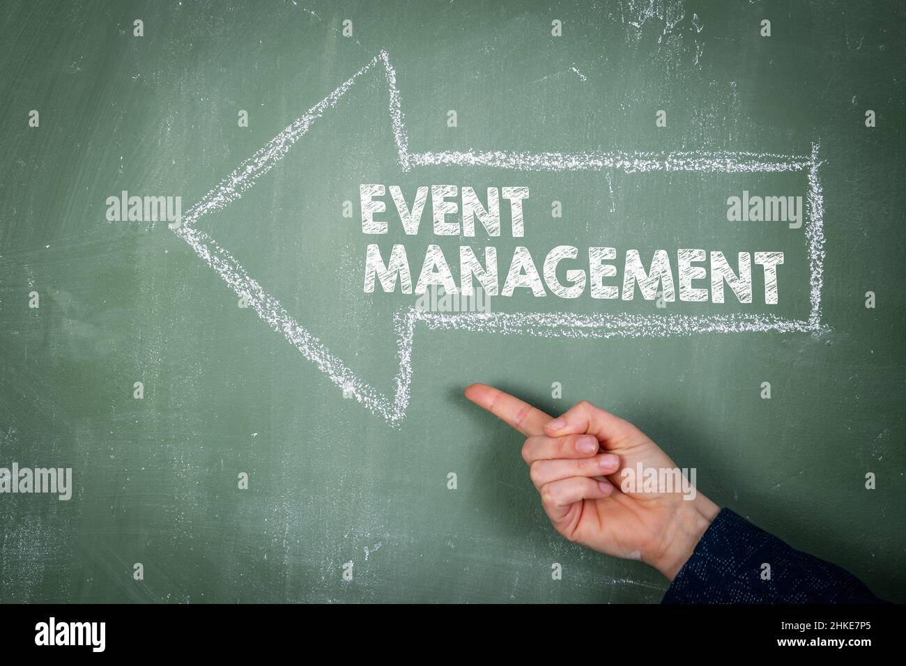 Event management. White arrow on a green chalkboard Stock Photo - Alamy