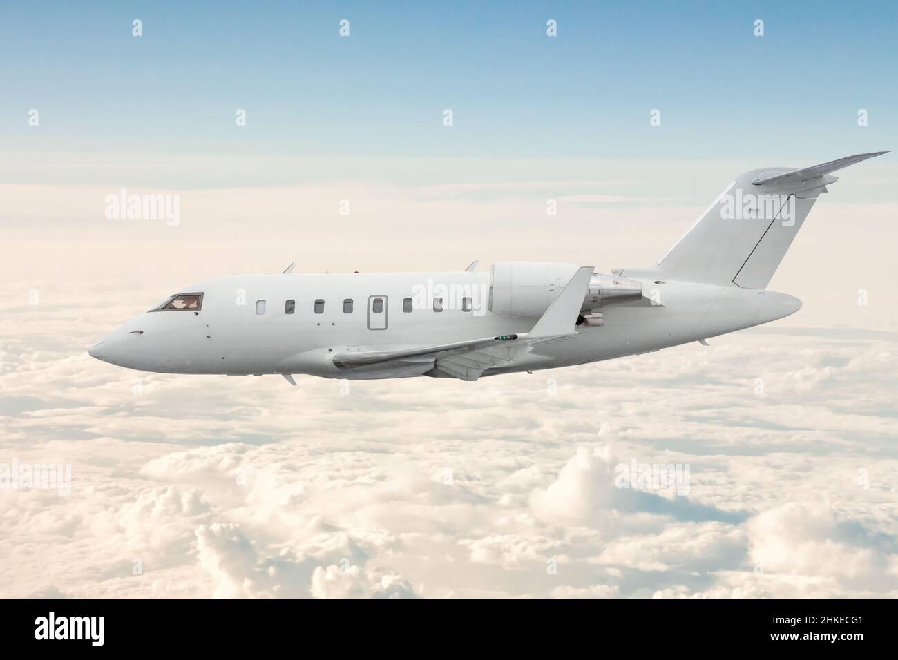 White corporate business jet flies in the air above the clouds Stock ...