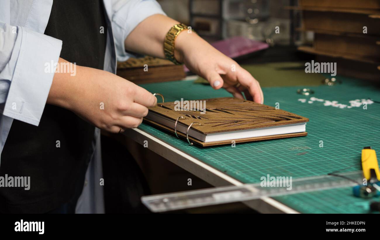 Female hands hold notebook with removable blocks and wooden cover ...
