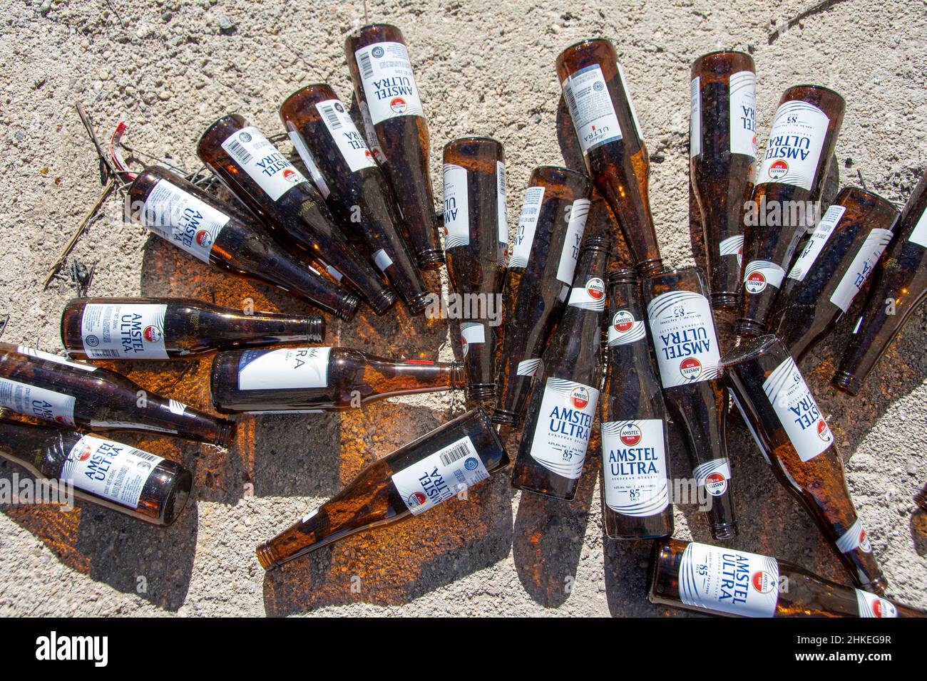 A couple dozen beer bottles strewn on the side of a highway, Mexican ...