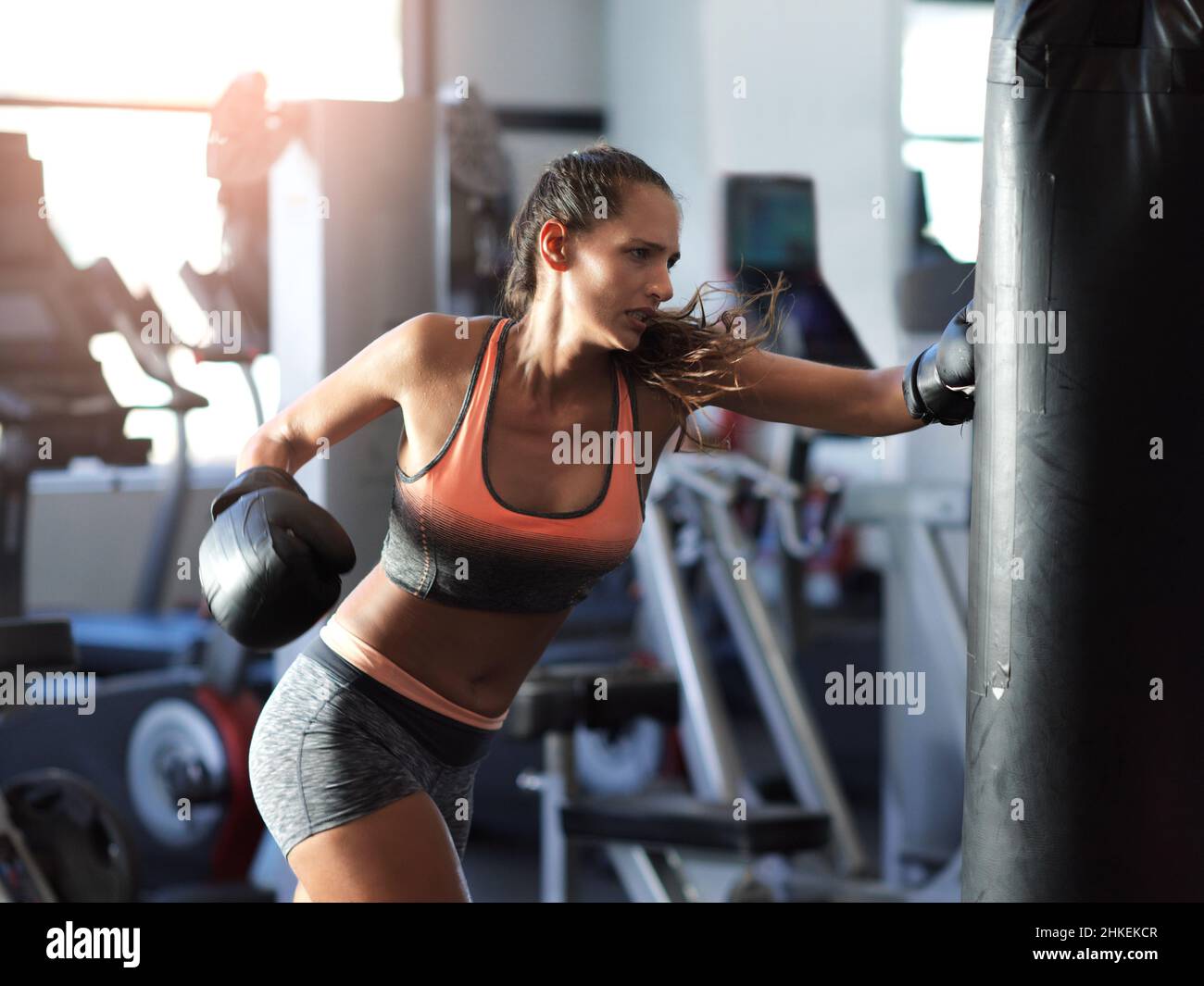 Southpaw elegance. Shot of a young female boxer working out on a ...