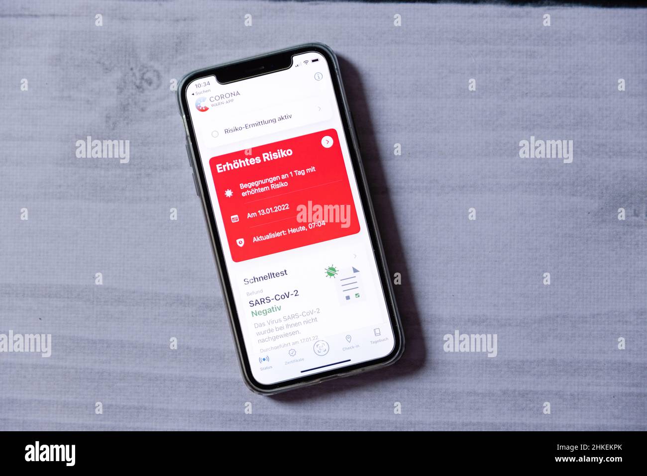 Top view of iPhone X with a Corona warn app on the screen on a table ...
