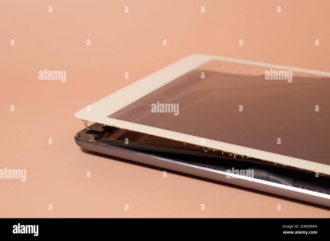 A broken tablet with a swollen battery and a dirty screen on a ...