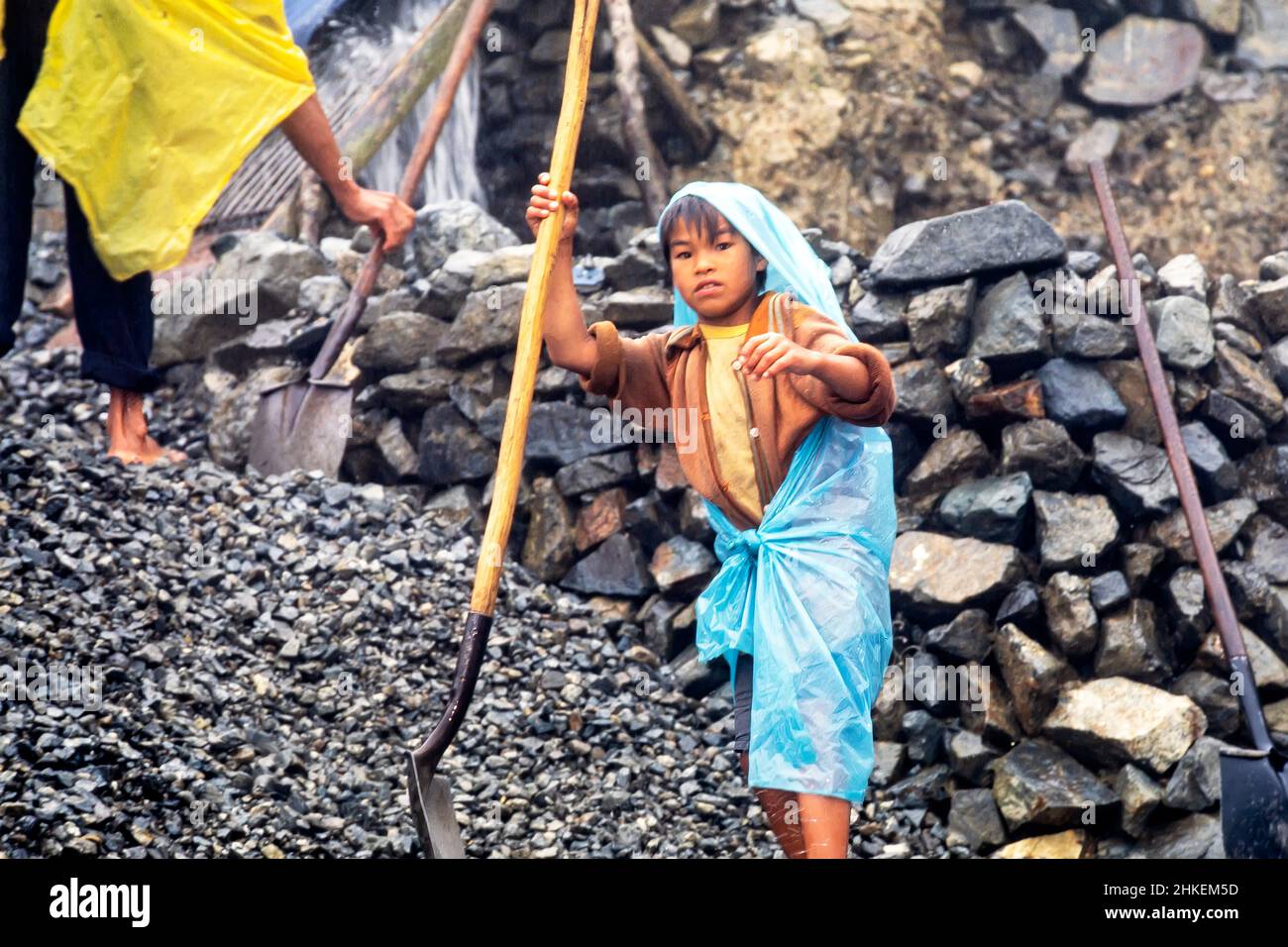Child labour repairing a rural road after landslide and heavy rain ...