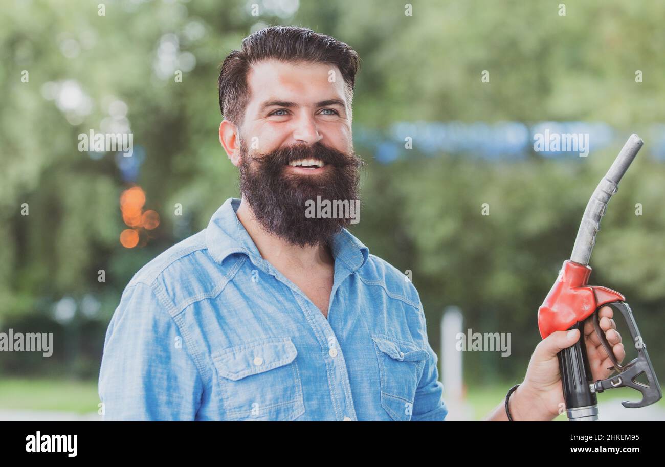 Gas station. Bearded man with fuel nozzle outdoor Stock Photo - Alamy