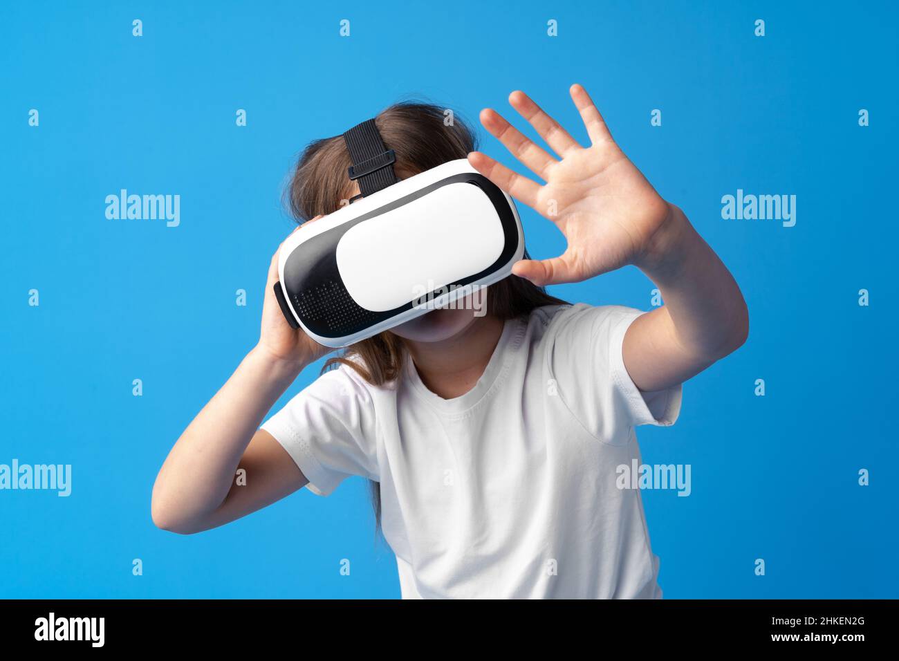 Girl with virtual reality glasses on blue background Stock Photo - Alamy