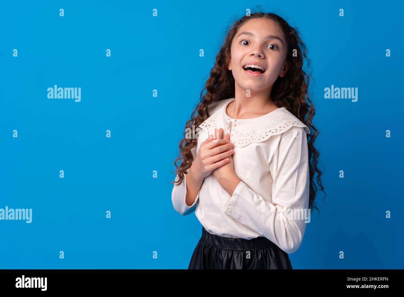 Shocked and surprised young teen girl against blue background Stock ...