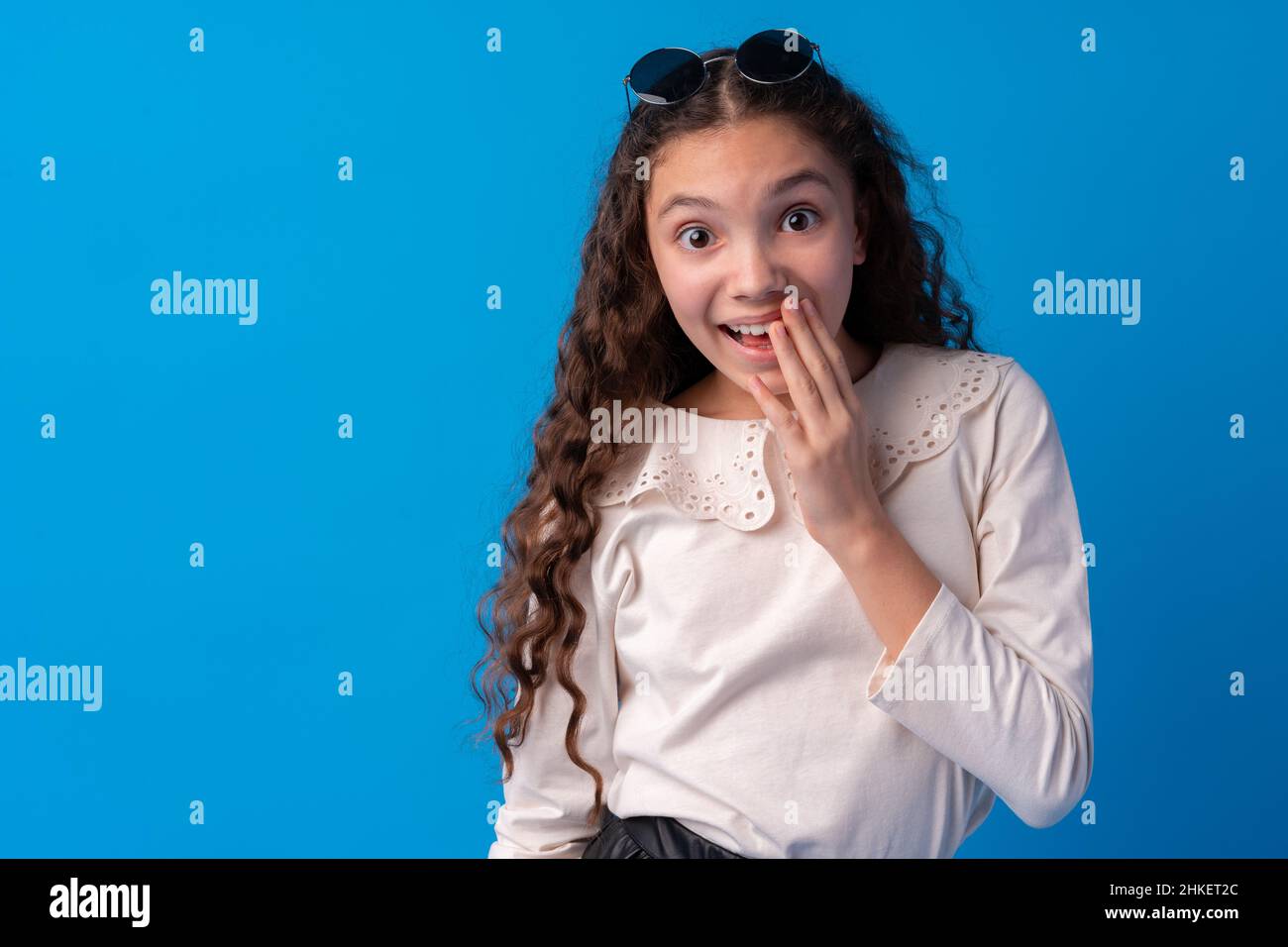 Shocked and surprised young teen girl against blue background Stock ...