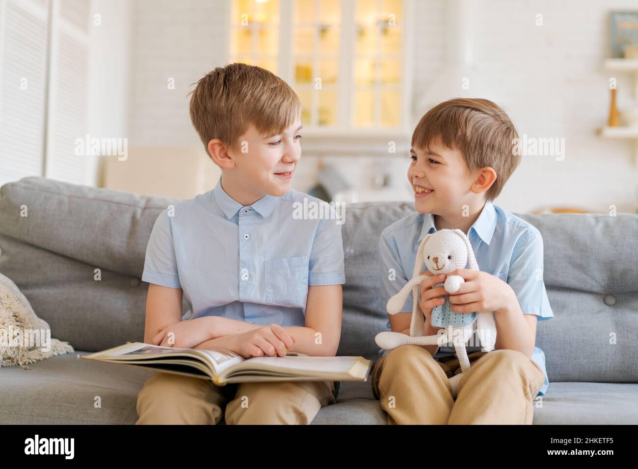 An older brother is reading book to his younger brother sitting on ...