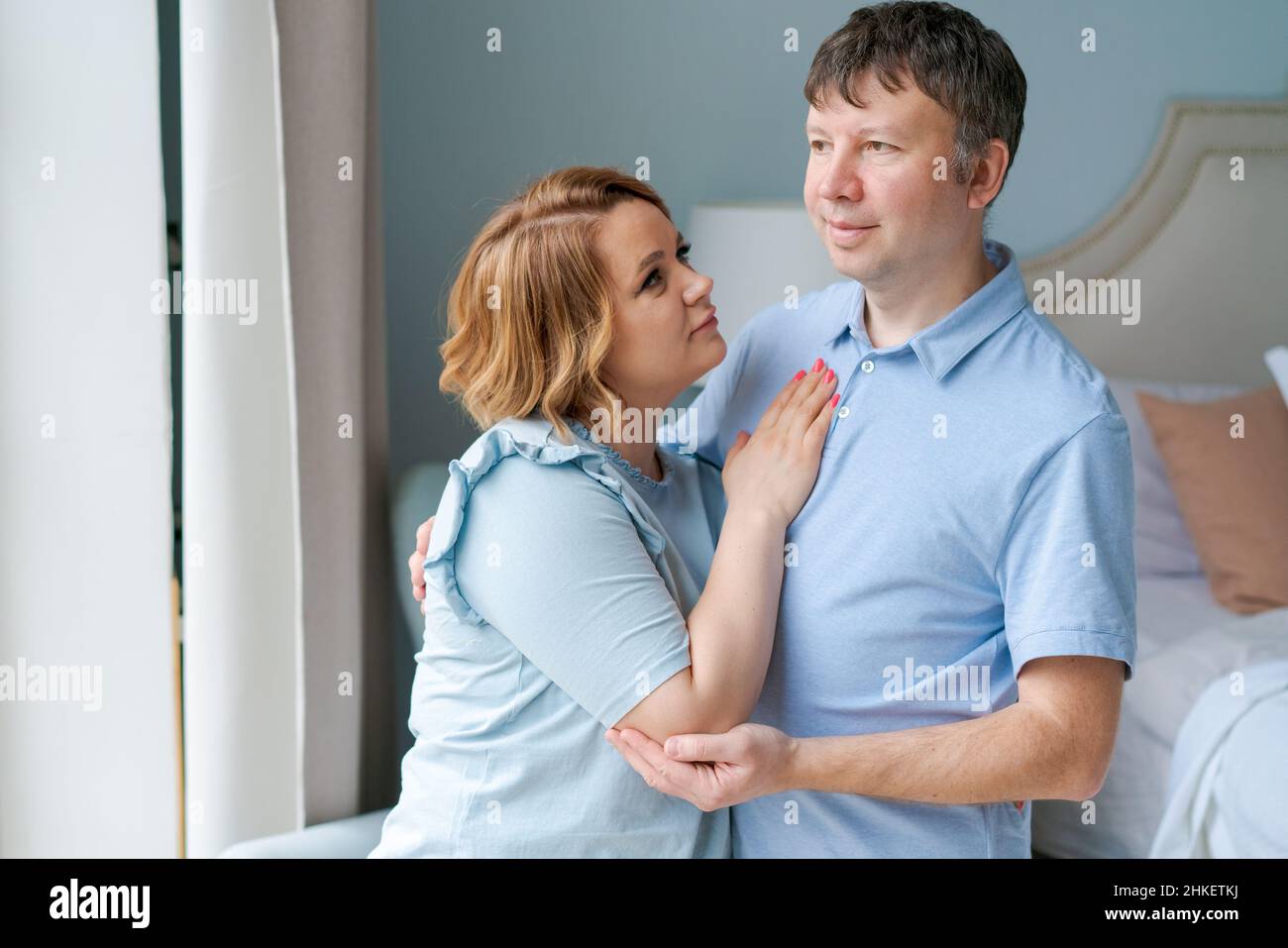 Dreamy couple family connection cuddling looking into distance through ...