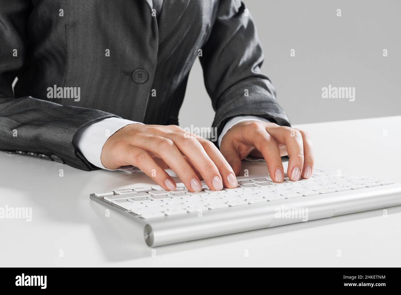 Closeup of businesswoman hand typing on keyboard with mouse on wood ...