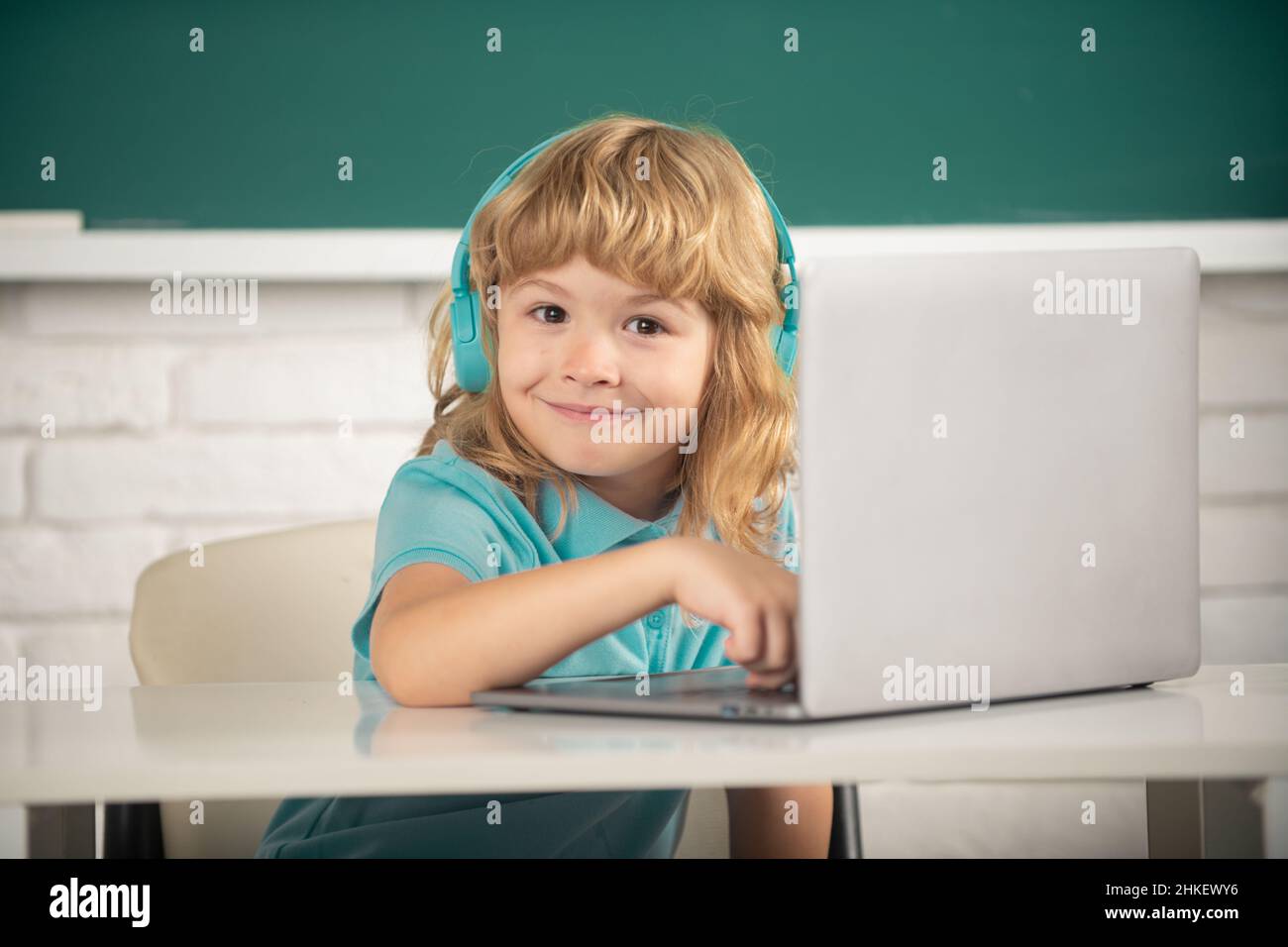 Cute funny child using laptop computer, kid boy studying through online ...