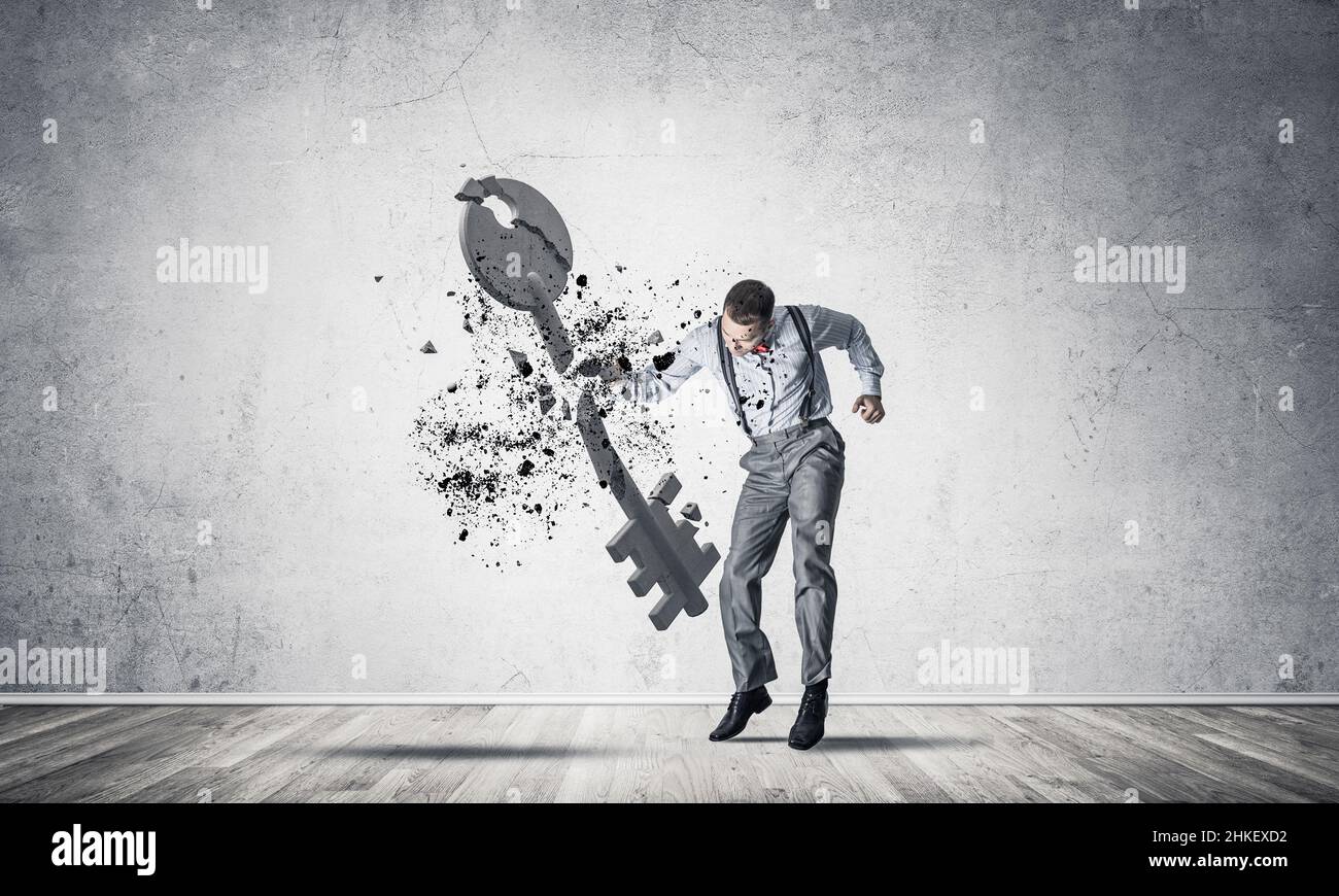 Breaking through access concept with man in room crashing concrete key ...