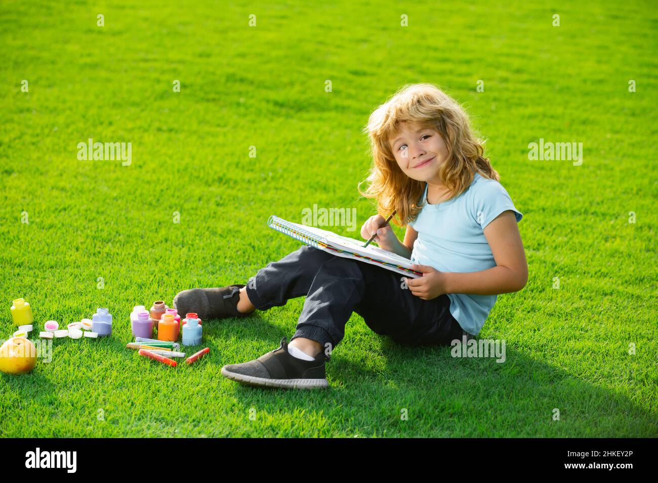 Kids painting in spring nature. Child boy drawing in summer park ...