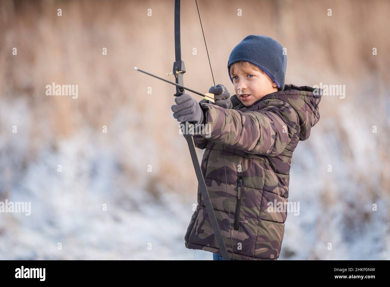 Portrait of a young boy shooting a bow Stock Photo - Alamy