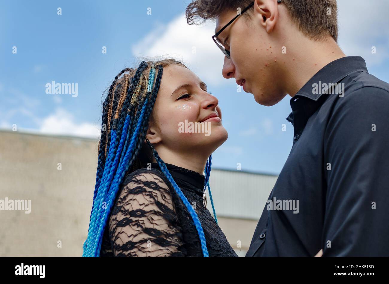 A young heterosexual couple in love against the sky. Man with glasses ...