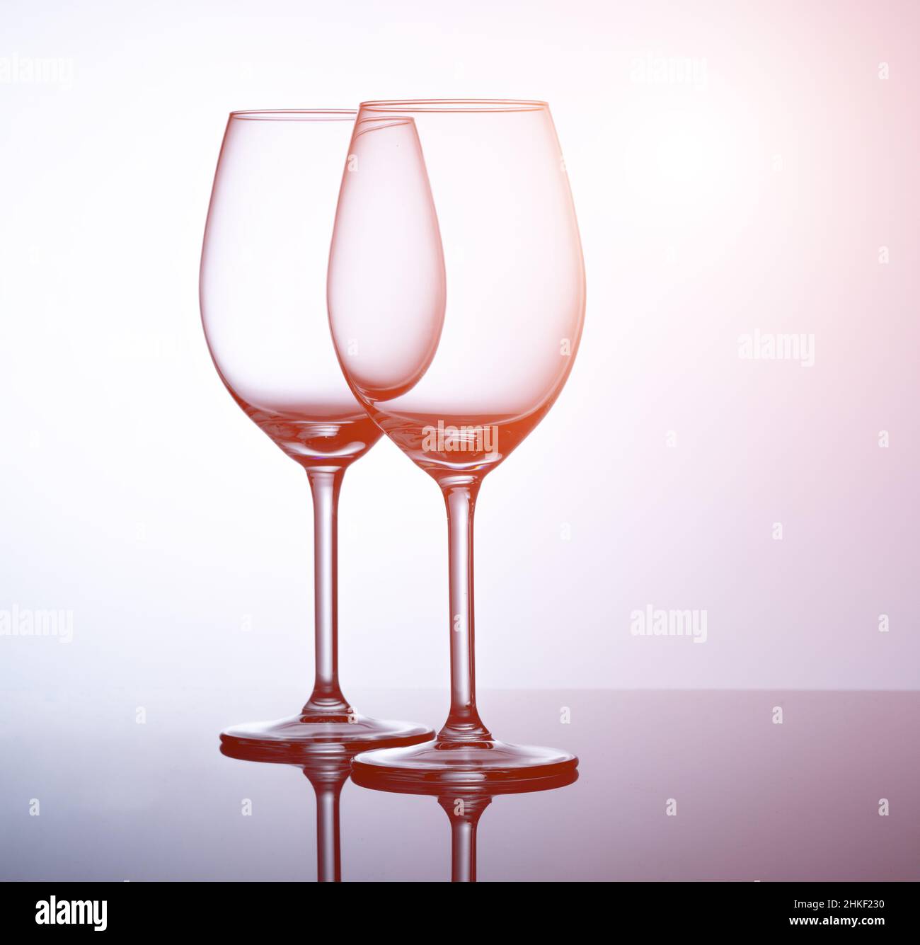 two glass goblets on a mirror surface Stock Photo - Alamy