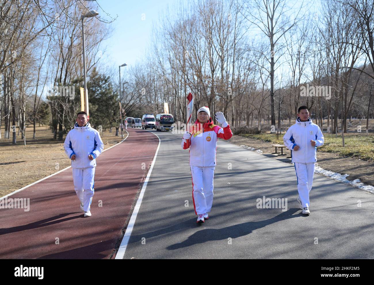 Beijing, China. 4th Feb, 2022. Torch bearer Ryu Seung Min (C) runs with ...