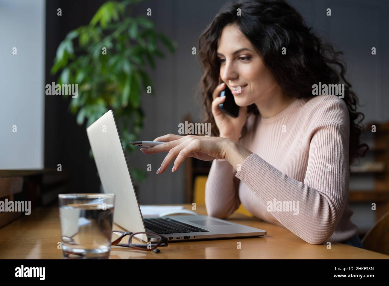 Smiling girl consultant talk to customer on phone call, read email ...