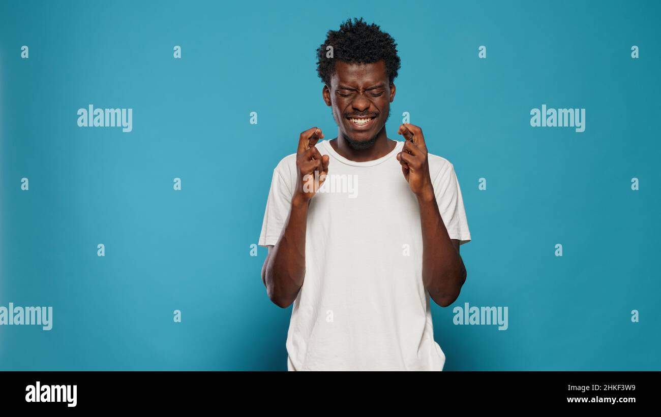 Hopeful person holding fingers crossed for good luck. Portrait of ...