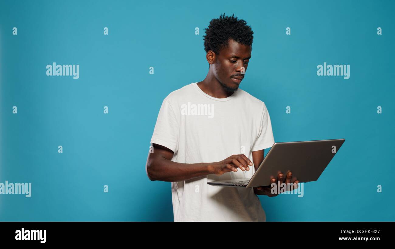 Young person holding laptop with internet connection. Portrait of adult ...