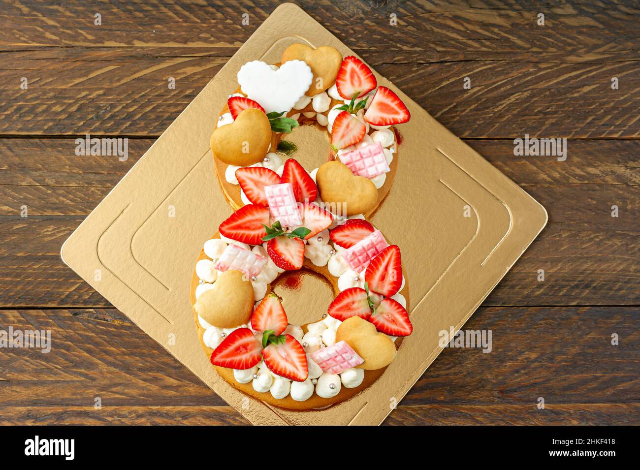 Sponge cake with strawberries, pink milk chocolate bars, silver ...