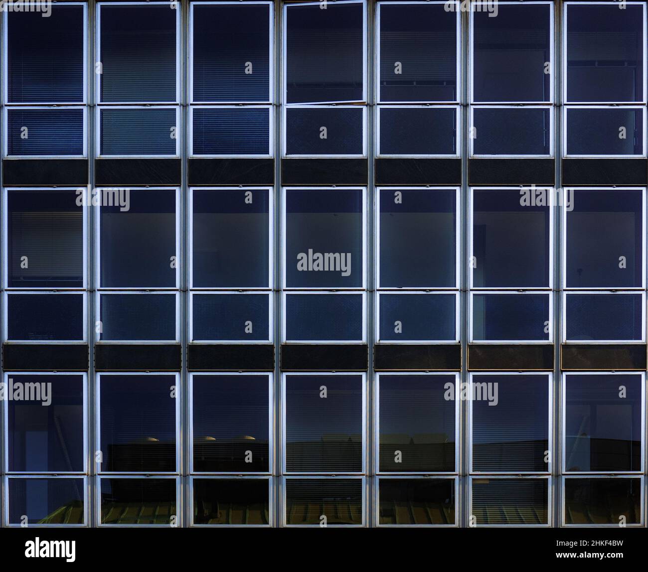 symmetrical facade of a building at night, blue sky reflected in the ...