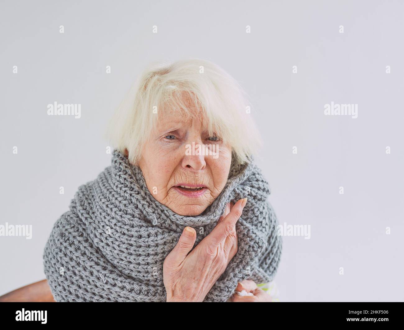 senior ill woman in scarf freezing cold at home. Health care, crisis ...