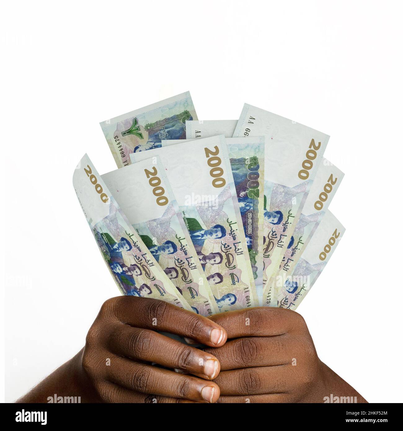Black hands holding 3D rendered 2000 Algerian Dinar notes. closeup of ...
