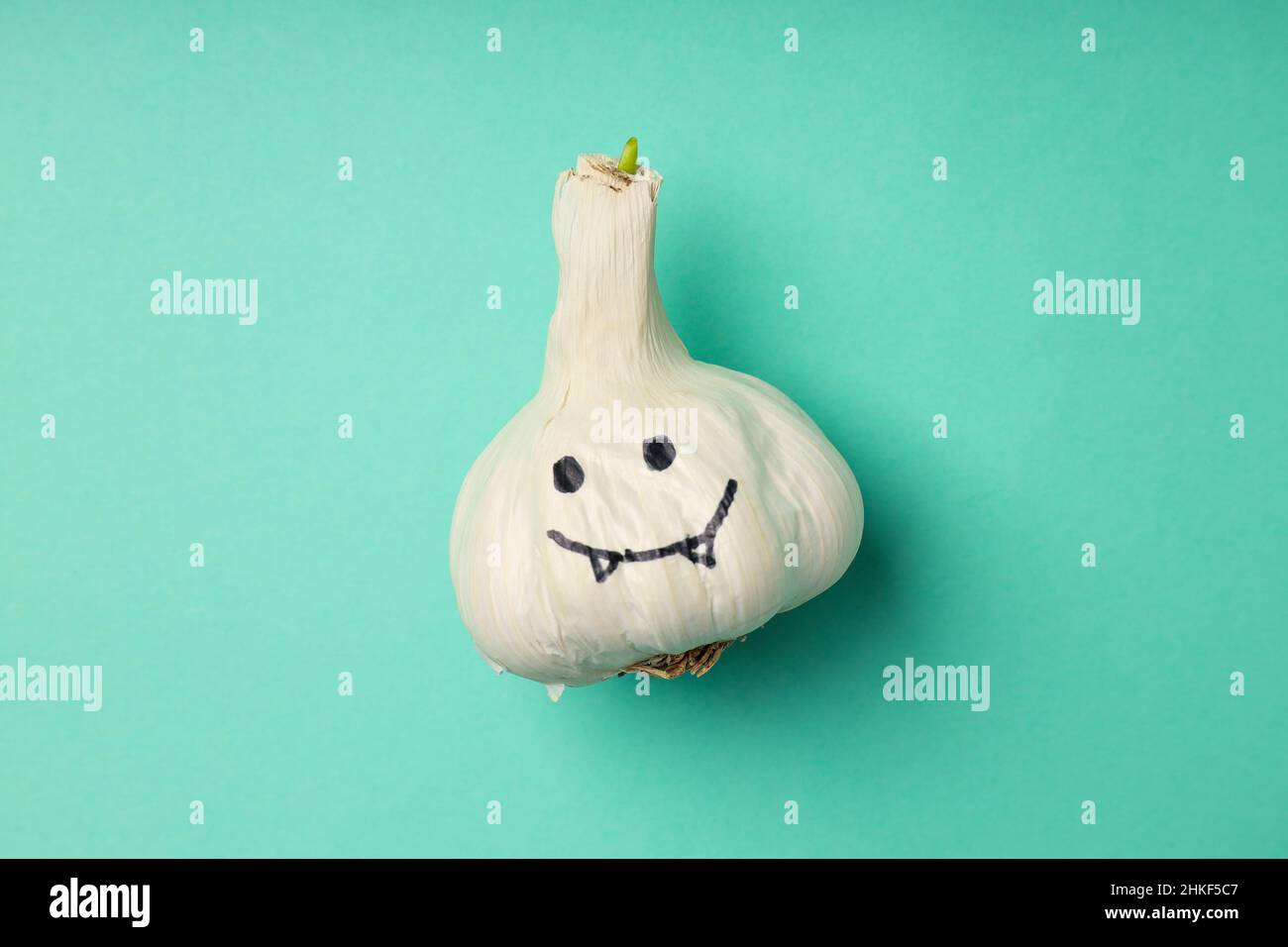 Garlic with eyes and fangs on mint background Stock Photo - Alamy